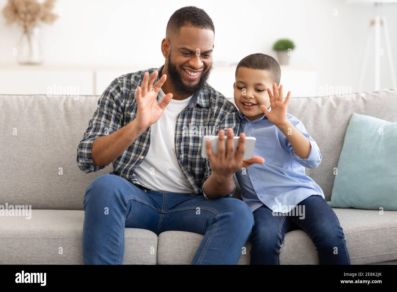 African Father And Son Using Phone Video Calling At Home Stock Photo ...