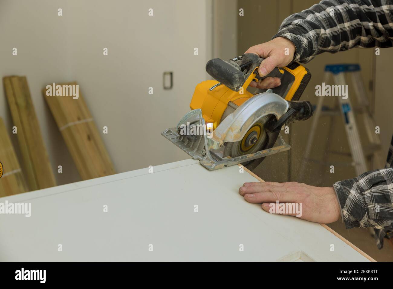 Close Up process cutting of hand circular saw at wood door cuts on a ...