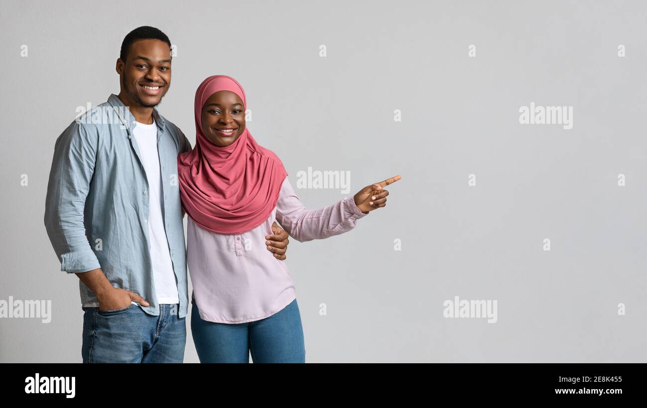 Cute black couple hugging and showing empty space Stock Photo - Alamy