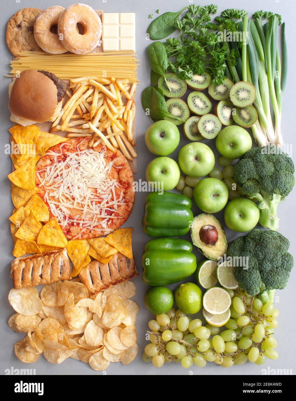 Assorted group of green fruits and vegetables alongside beige junk food ...