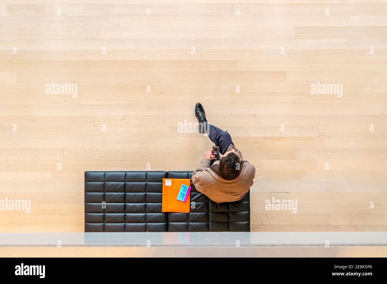 top view of man sitting on vinyl seat on cell phone in New York art ...