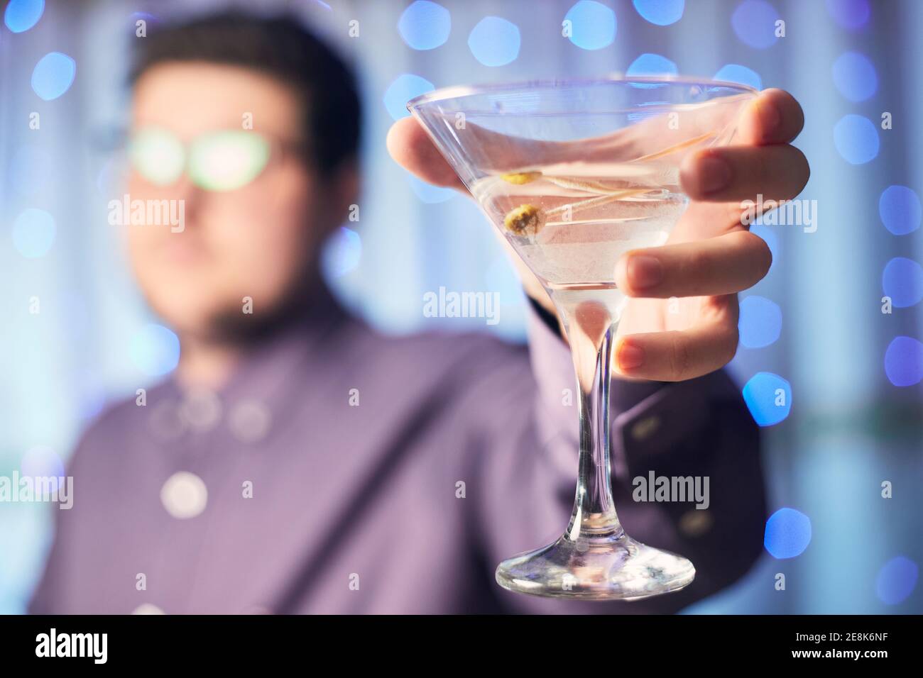 Caucasian man holding glass of martini with olive on background Stock ...