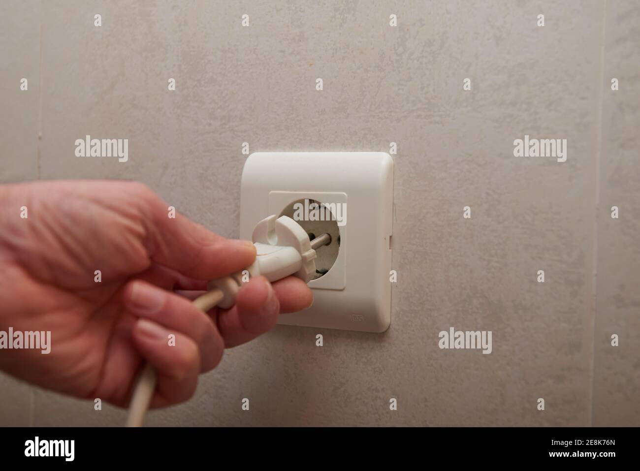 A man's hand plugging in an electrical plug Stock Photo - Alamy