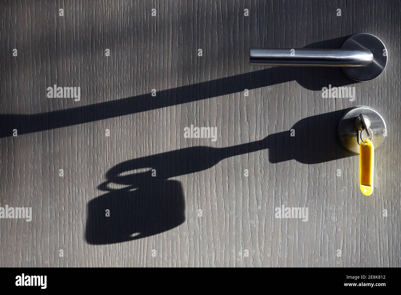 door key with label tag and its silhouette over the door Stock Photo ...
