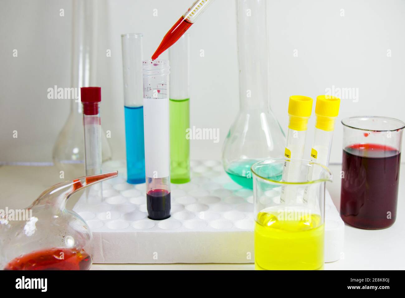 An isolated shot of different flasks with colorful liquid and a pipette ...