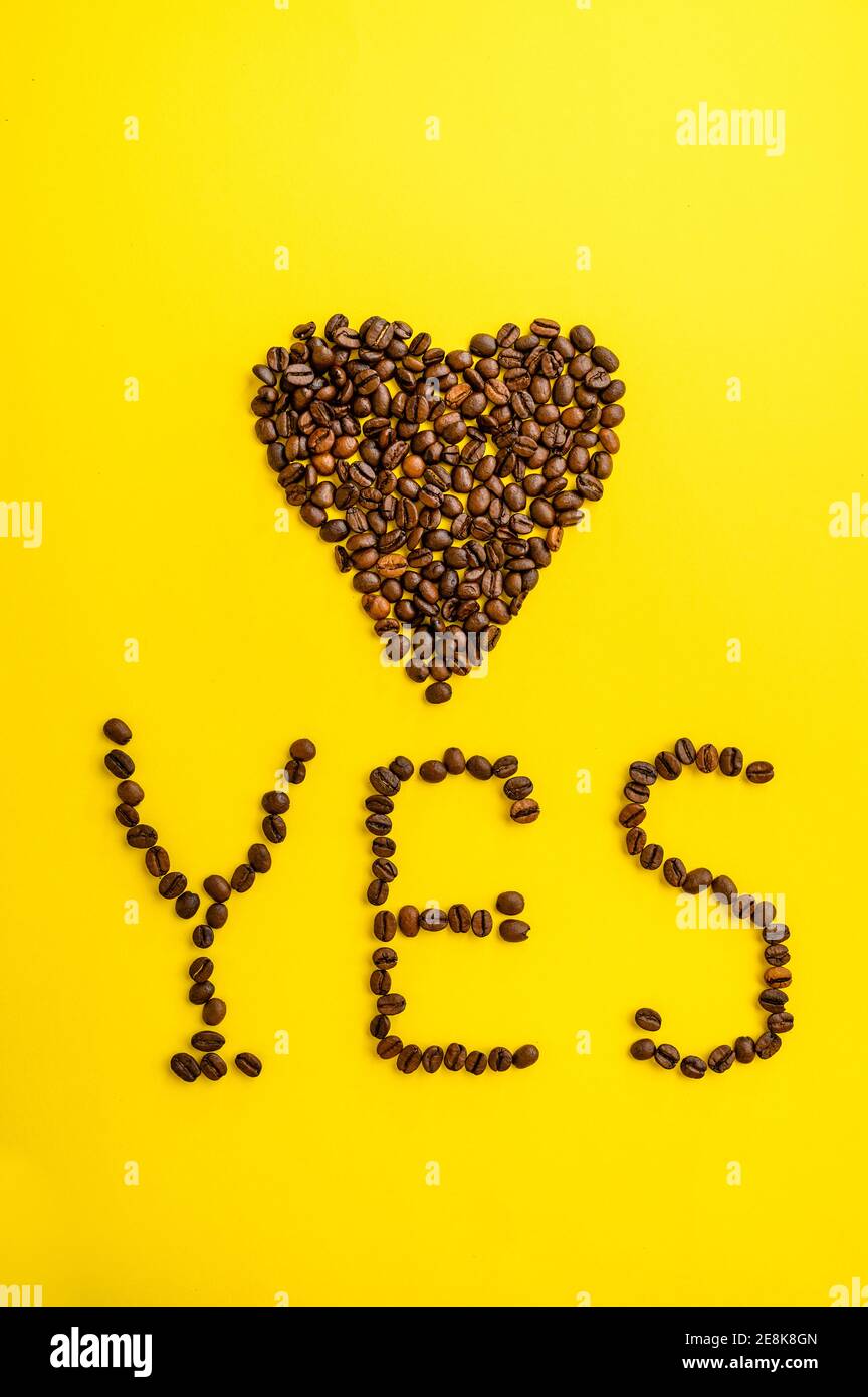 Coffee bean heart and yes word, yellow background Stock Photo - Alamy