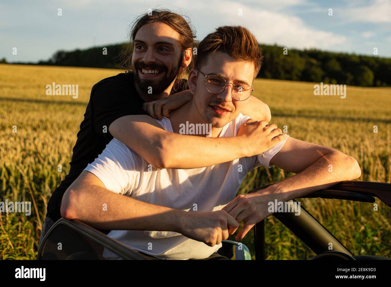 Laughing and hugging white european young models boys smiling outside ...