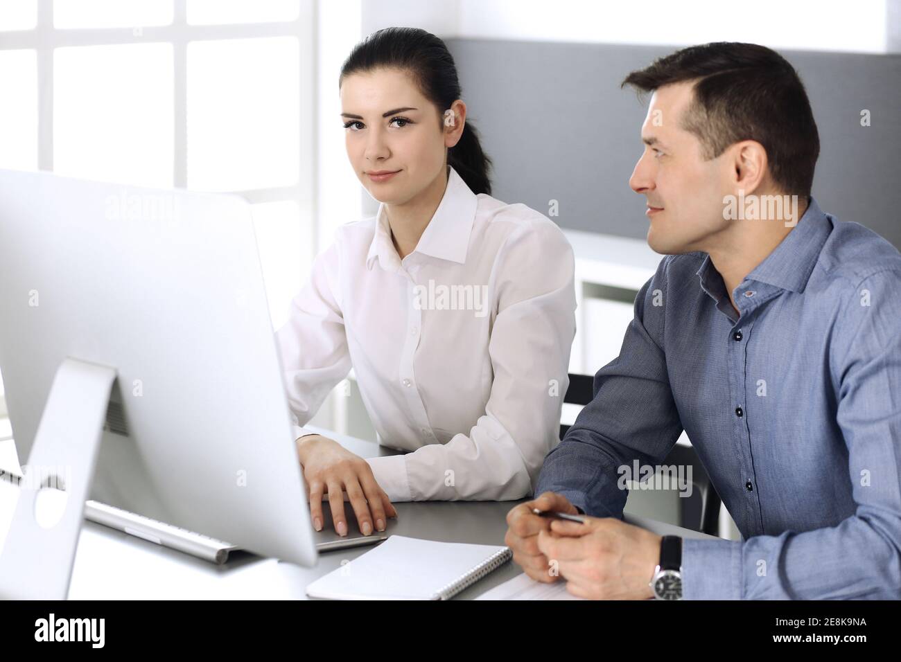 Cheerful smiling businessman and woman working with computer in modern ...