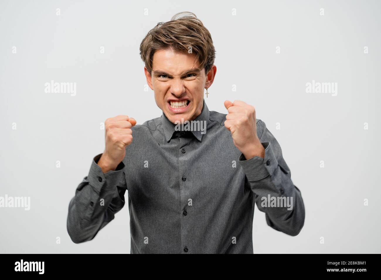 Ready to fight young man defending himself hands in fists in grey shirt ...