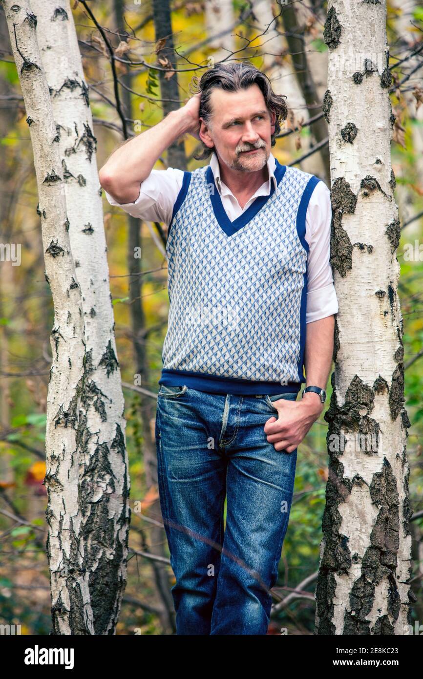 portrait of handsome man in his 50s standing in the forest Stock Photo ...