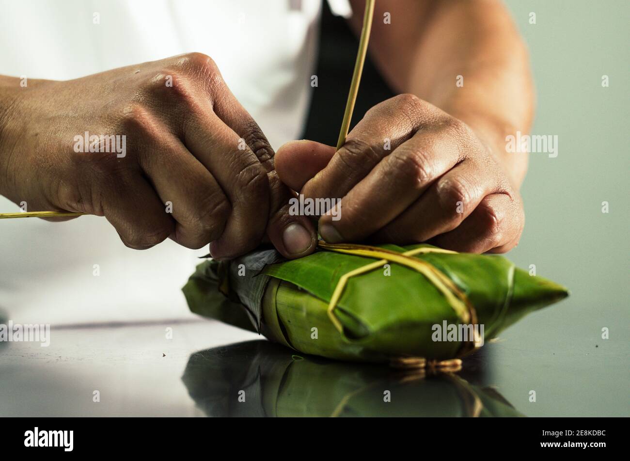 Peruvian hands tying a traditional tamale with banana leaves Stock ...