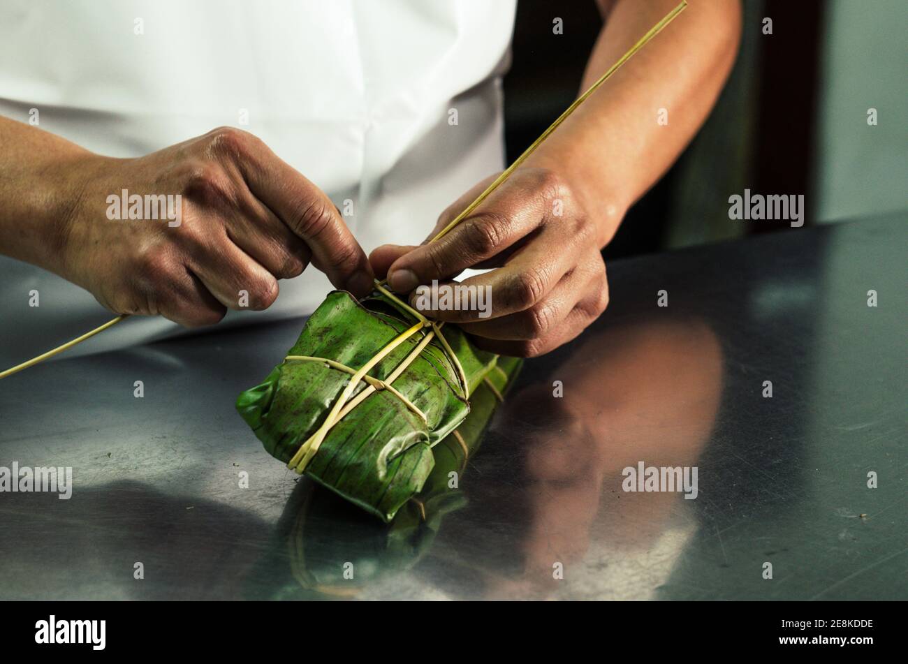 Peruvian hands tying a traditional tamale with banana leaves Stock ...
