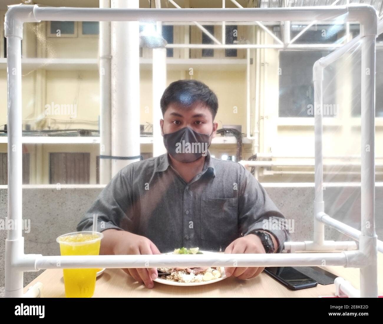 Soft focus on Partition on front of man wearing masks were eating lunch ...