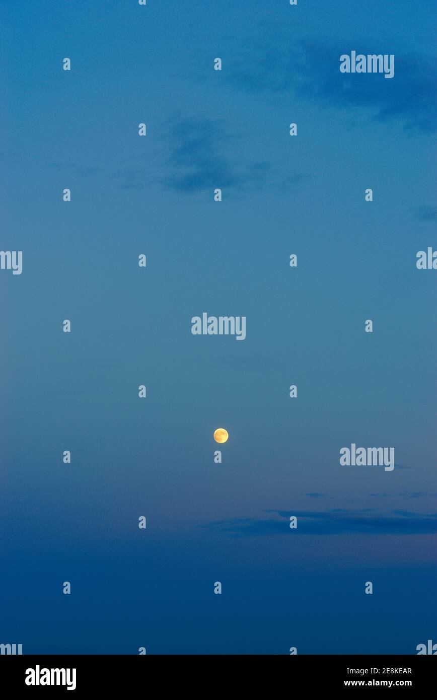 full red moon rising on blue sky background Stock Photo - Alamy