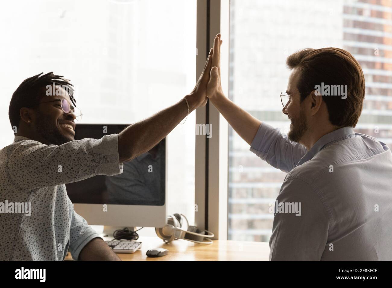 Diverse men colleagues join hands in high five celebrate achievement ...