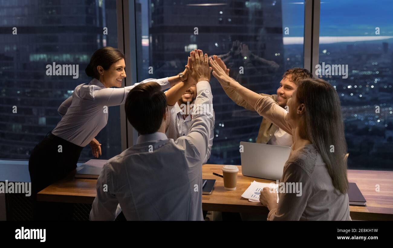 Happy multinational workers unite hands above conference desk celebrate ...