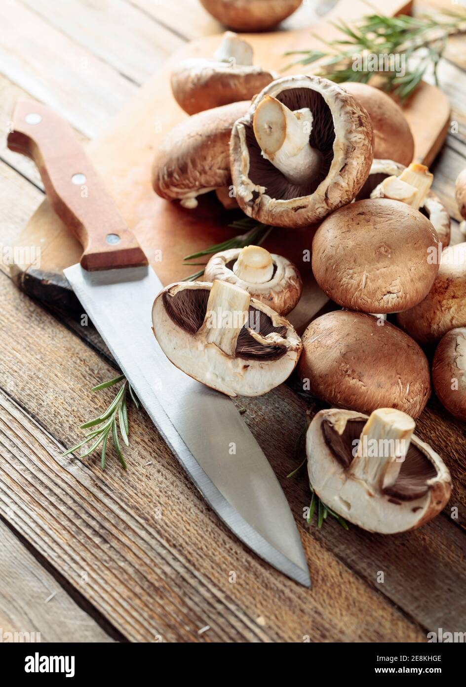 Champignon with rosemary on an old wooden table Stock Photo - Alamy