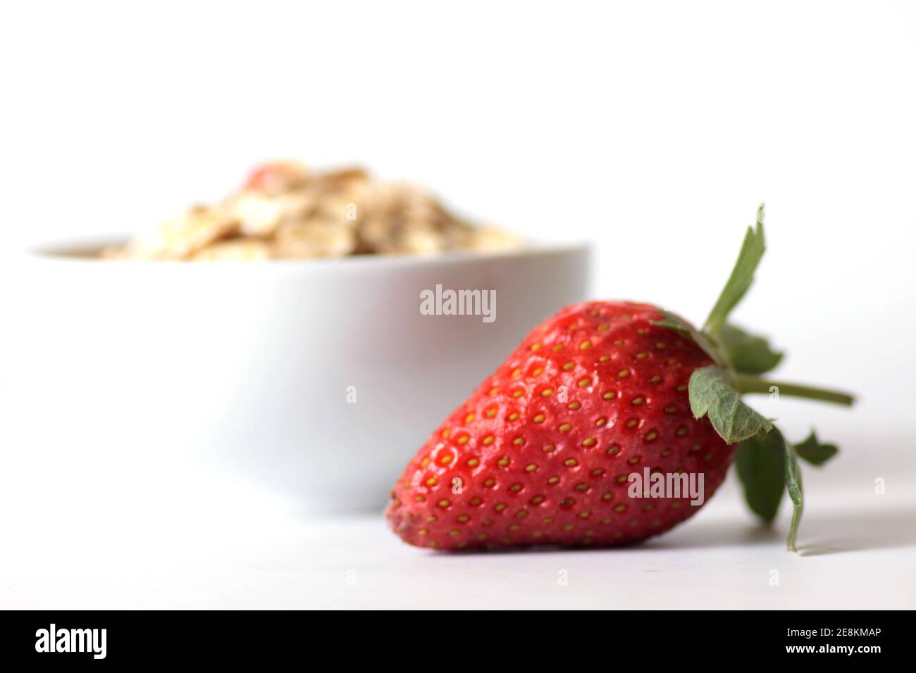 strawberry and a bowl of granola isolated against white background ...