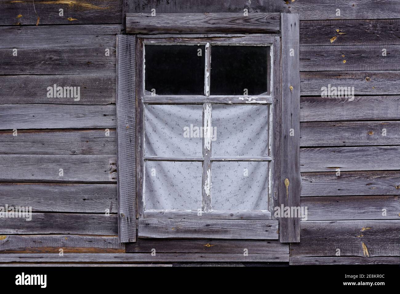 Rectangular window with a white frame in an old country house against a ...