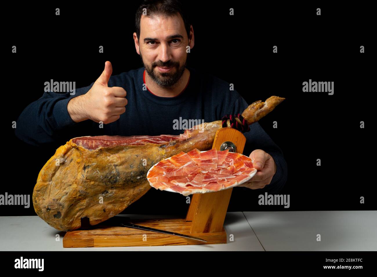 Bearded man with a ham knife ready to cut a piece of typical Spanish ...