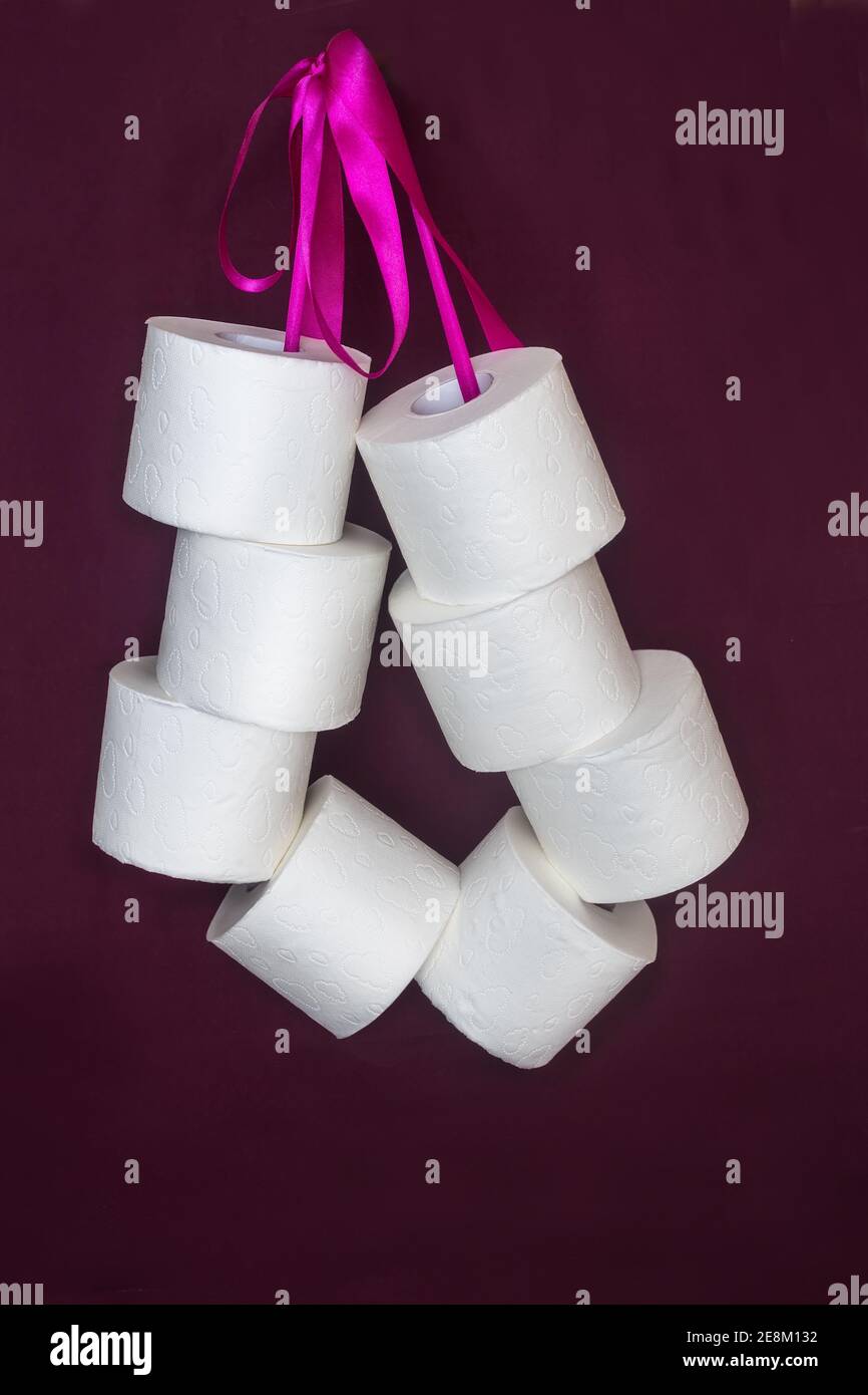 On a dark background, a roll of white toilet paper is connected by a ...