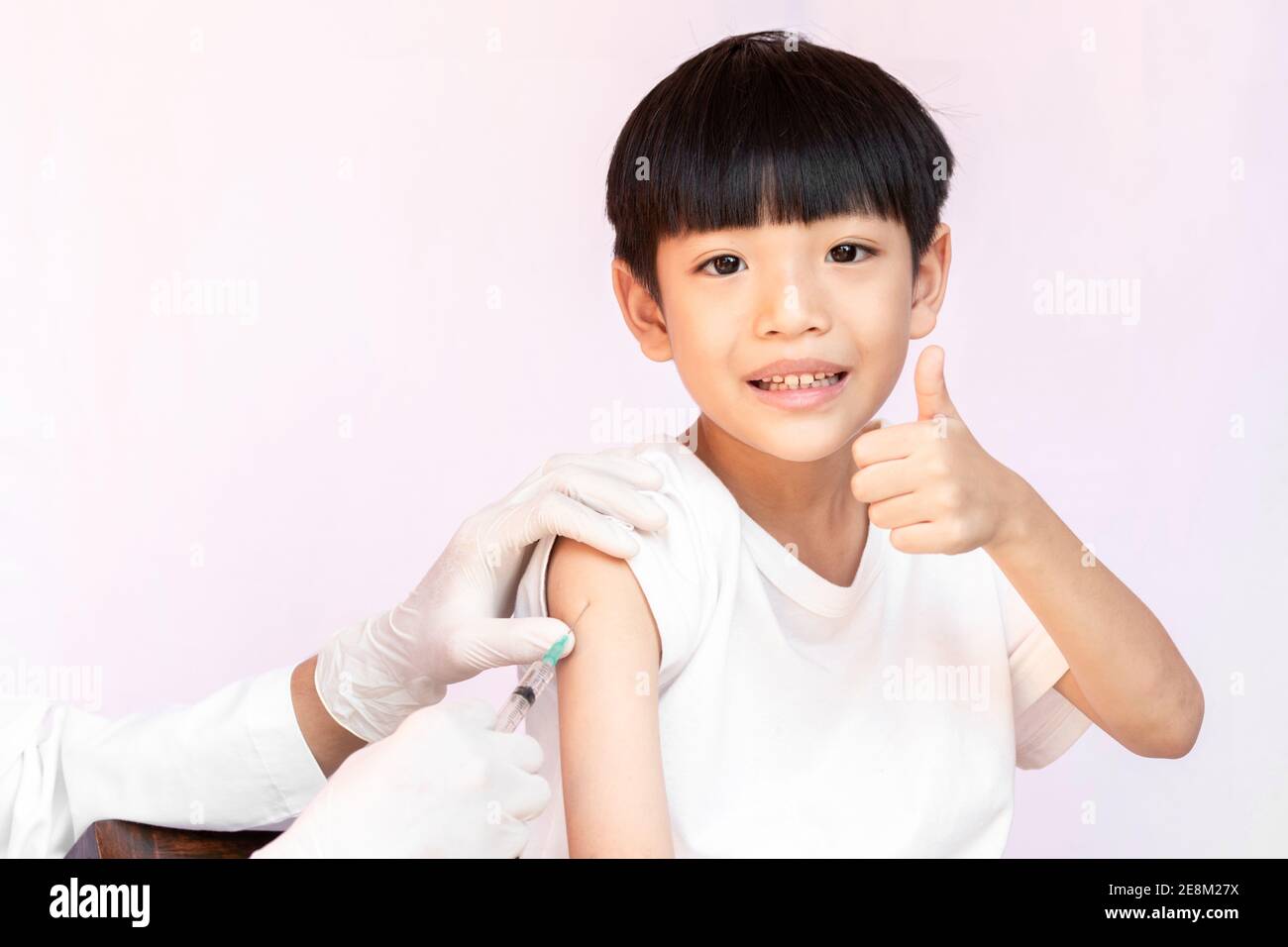 A happy smiling kid While being vaccinated. doctor vaccinating little ...