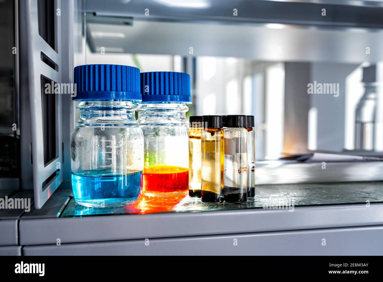 Closeup of laboratory glassware filled with blue and orange liquids ...