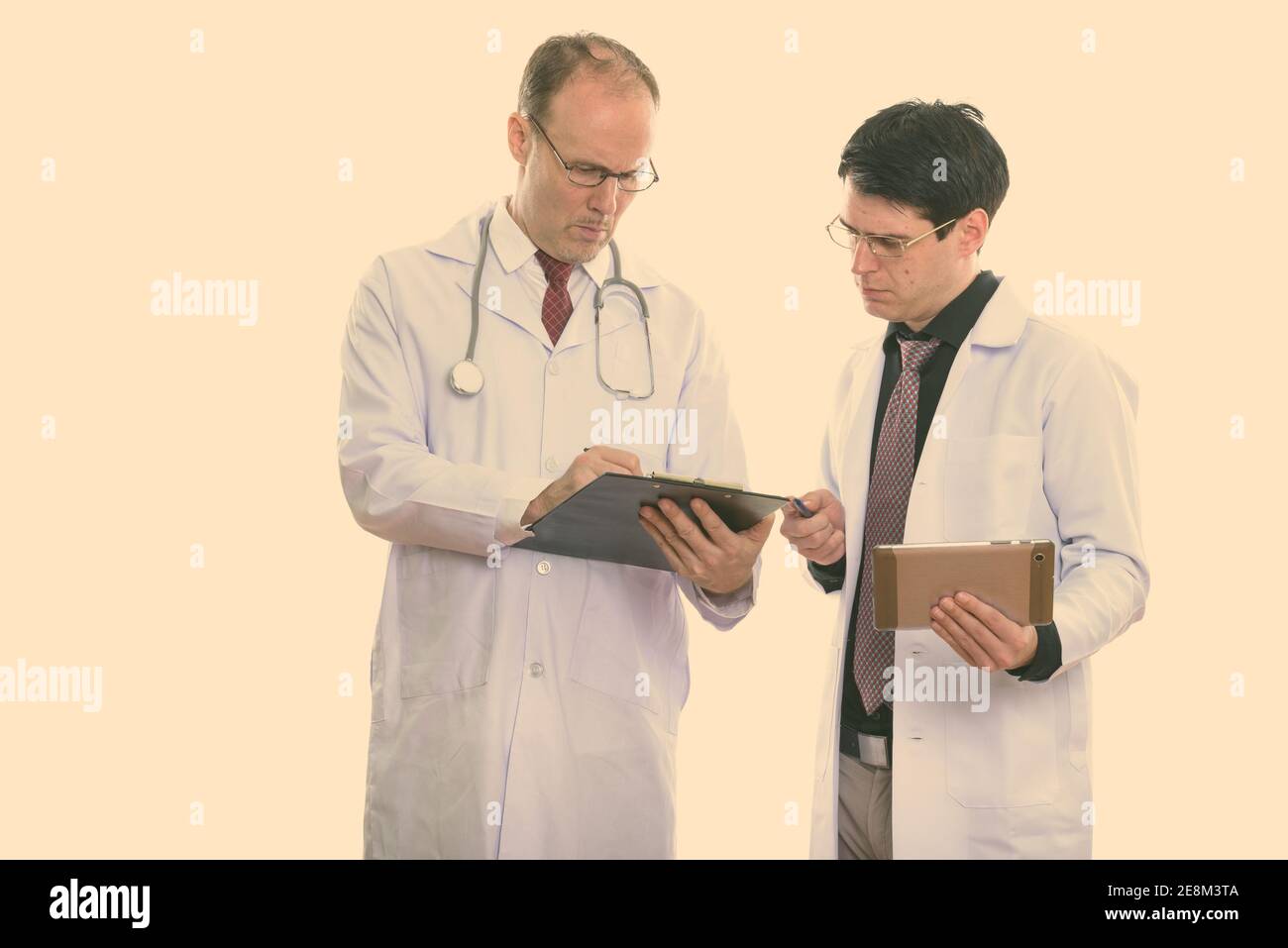 Portrait of two man doctors against studio background Stock Photo - Alamy