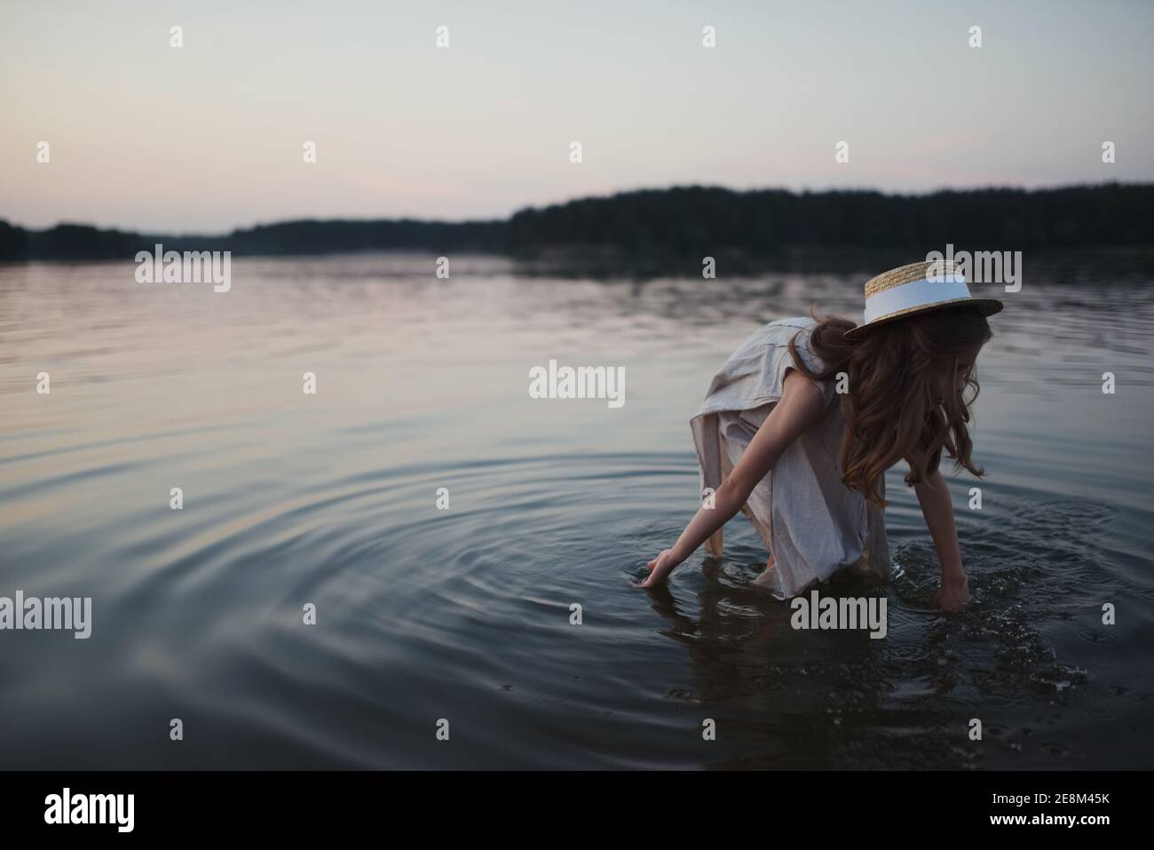 little cute girl with long hair on the lake Stock Photo - Alamy