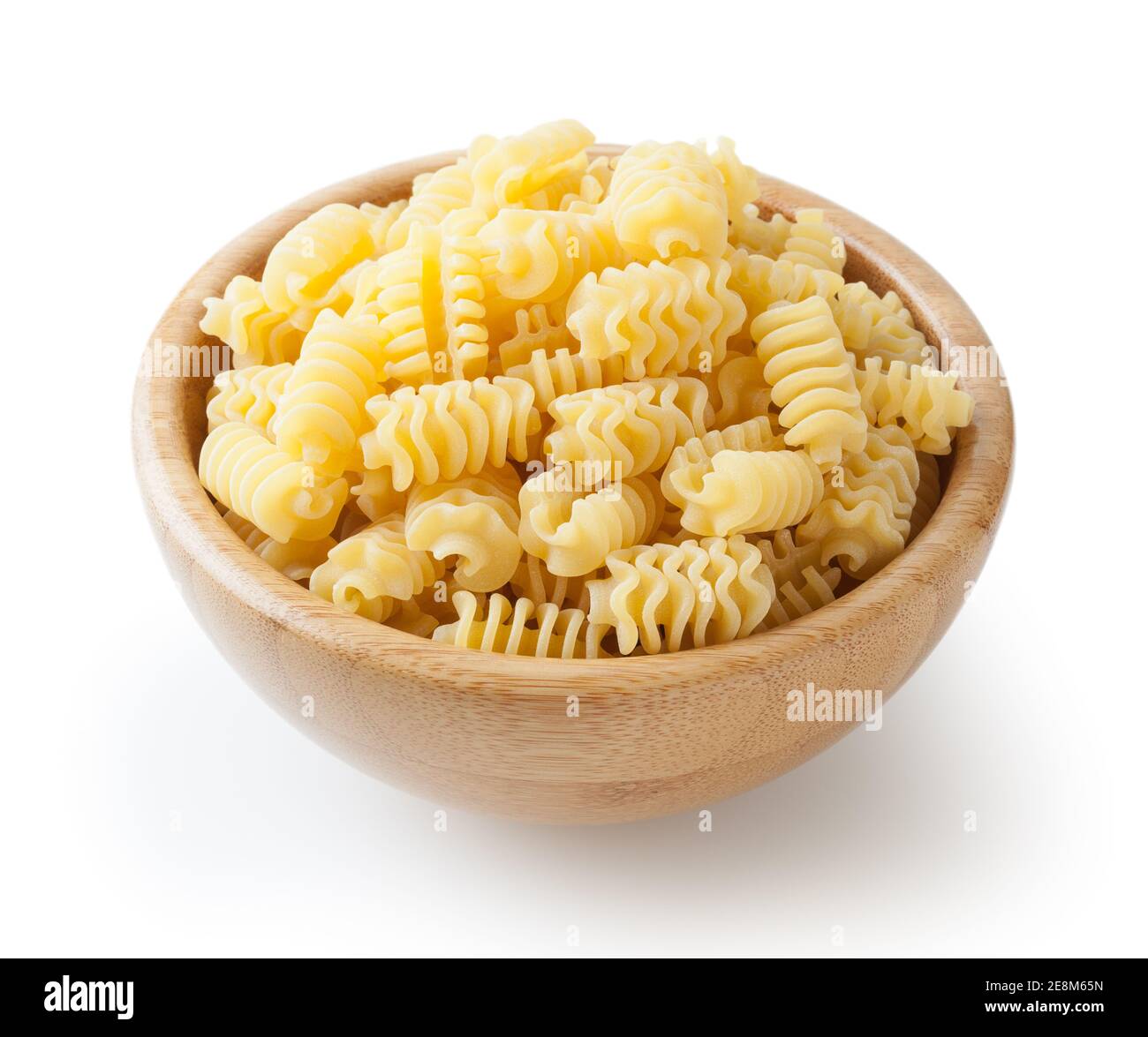 Uncooked radiatori pasta in wooden bowl isolated on white background ...