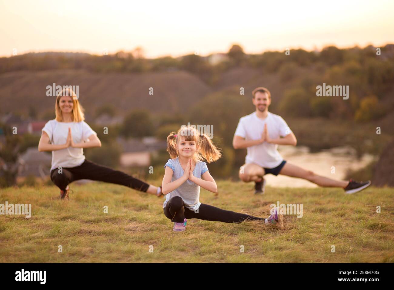Happy healthy active family of three do gymnastic exercises together ...