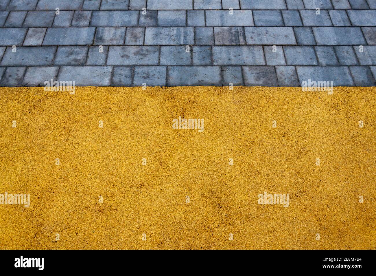 Playground with yellow rubber surface coating and grey tiles Stock ...
