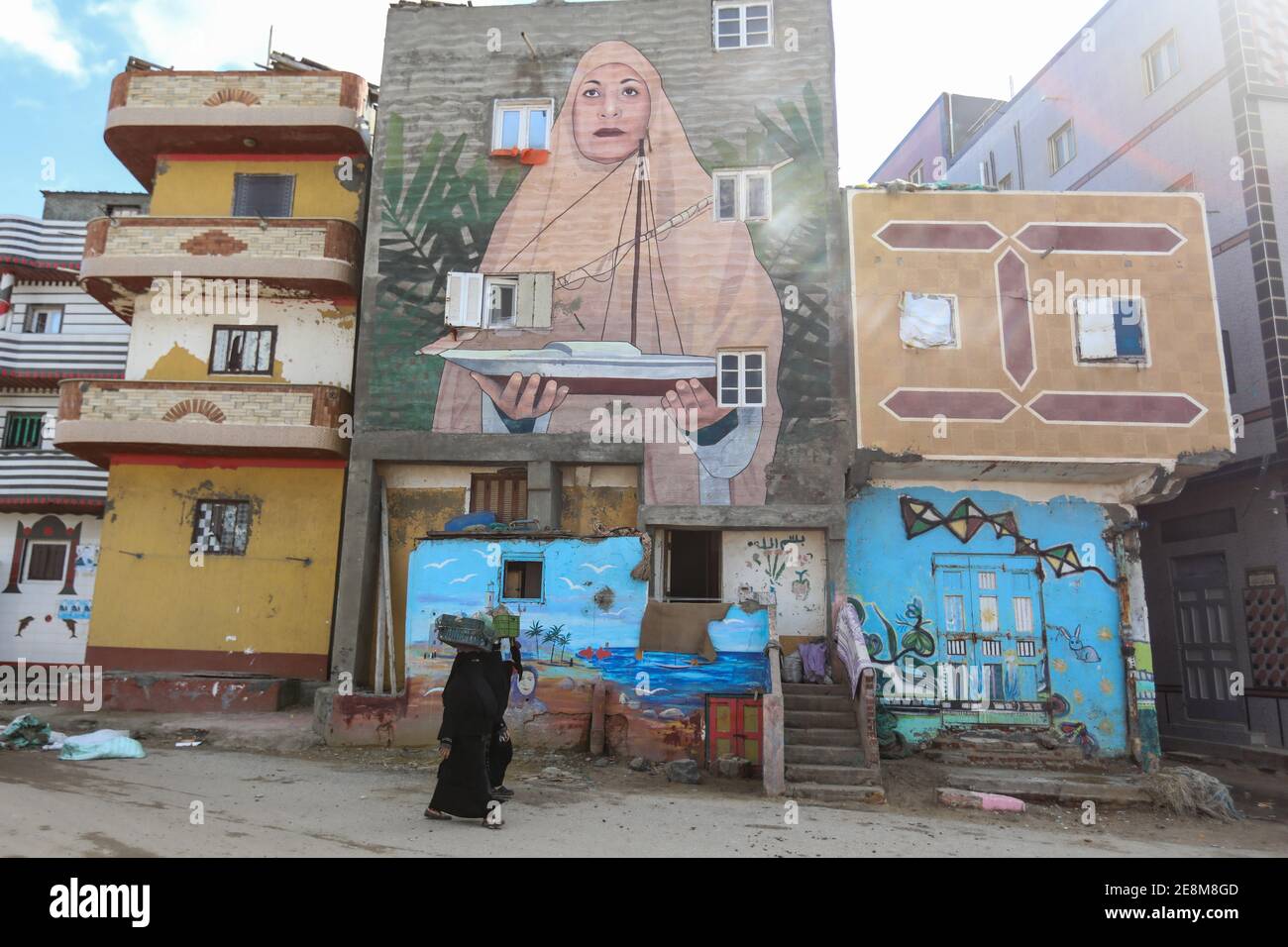 Burullus, Egypt. 30th Jan, 2017. Women walk past a large mural painted ...
