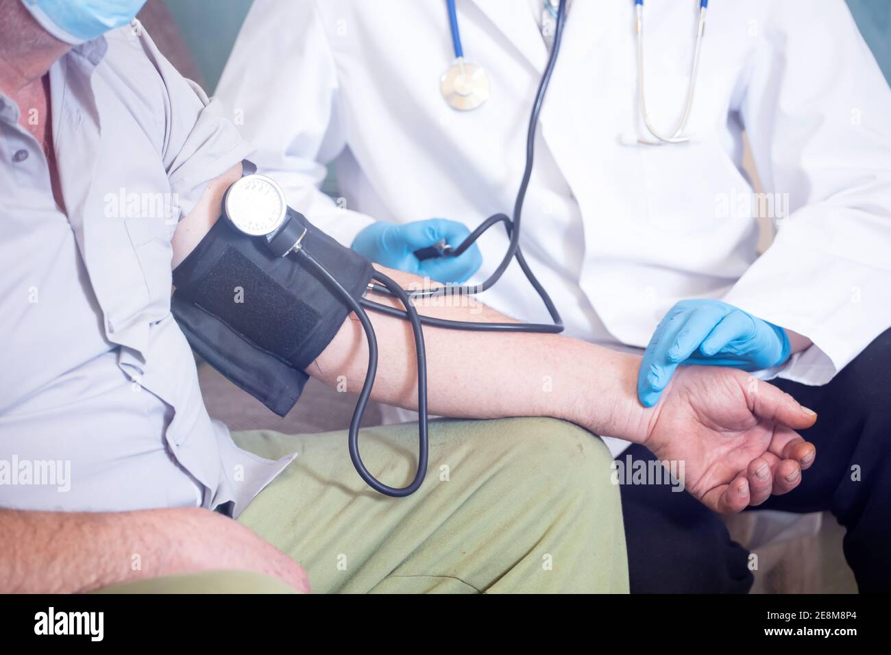 Doctor checking old man patient arterial blood pressure Stock Photo - Alamy