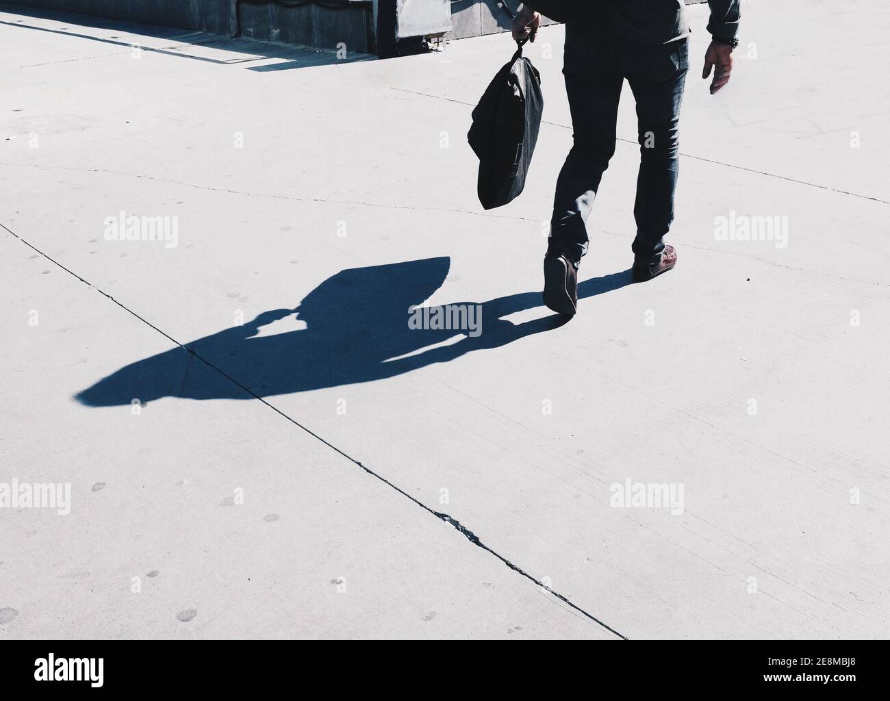 A shadow of a man walking on the asphalt Stock Photo - Alamy