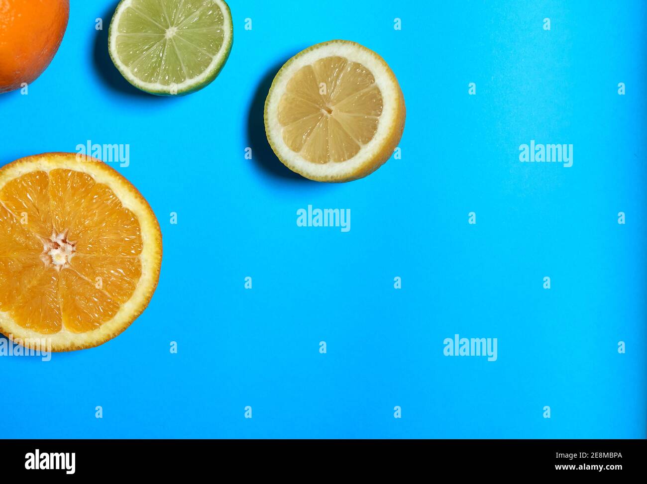 Split oranges, limes and lemons with skin on a blue background. CITRUS ...
