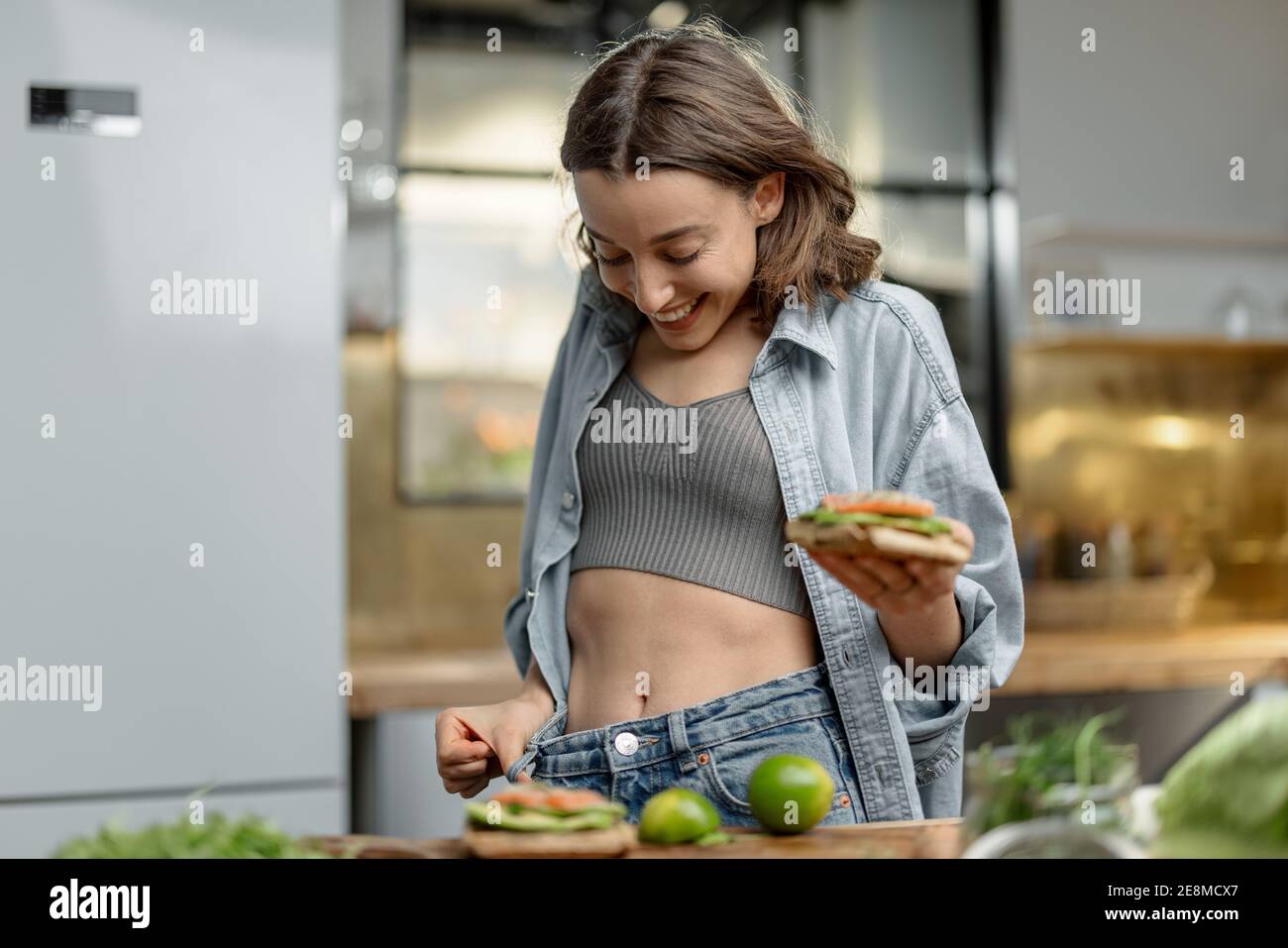 Happy slim woman showing her weight loss Stock Photo - Alamy