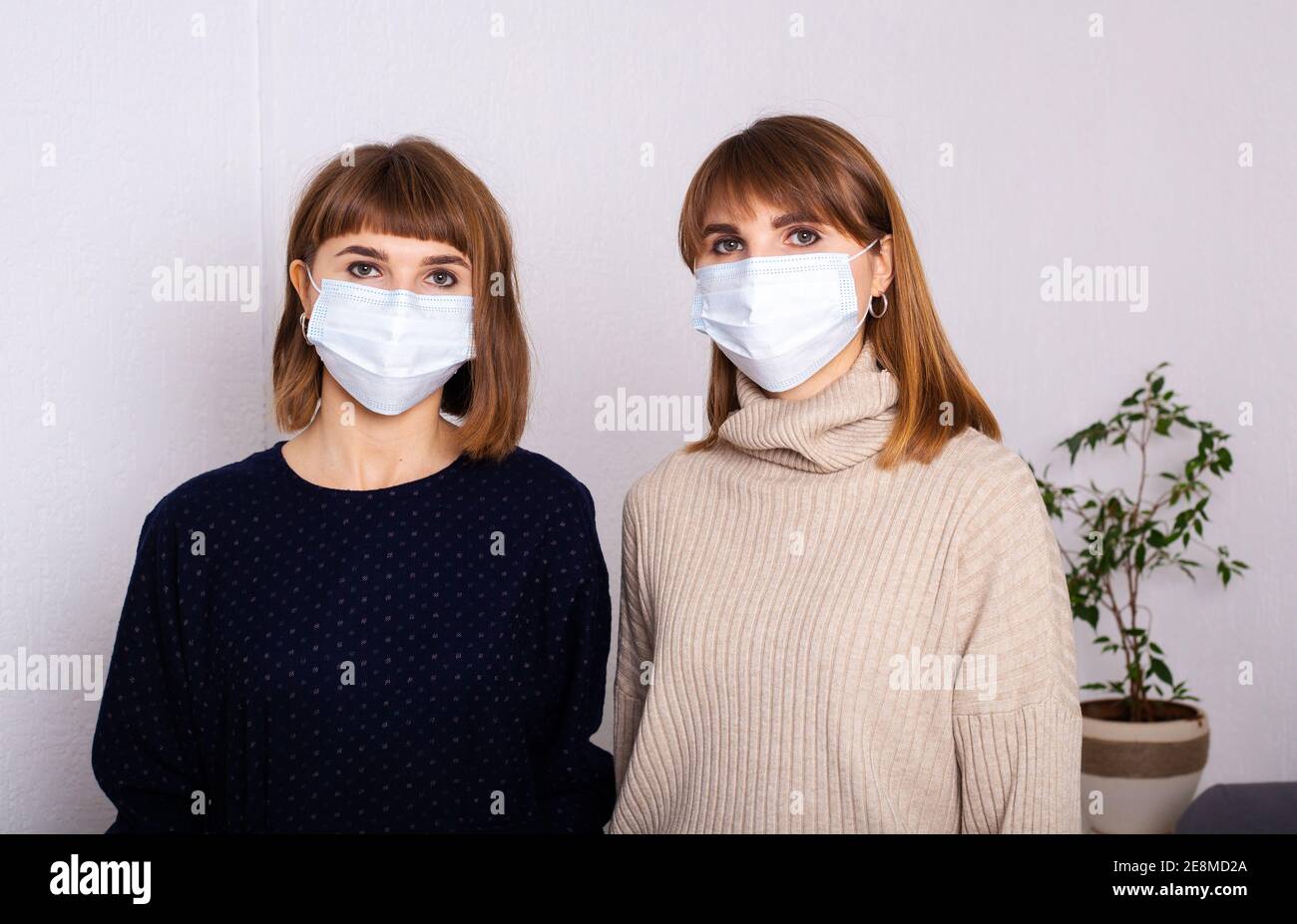 Two twins sisters masked women at work. Social distancing. New reality ...