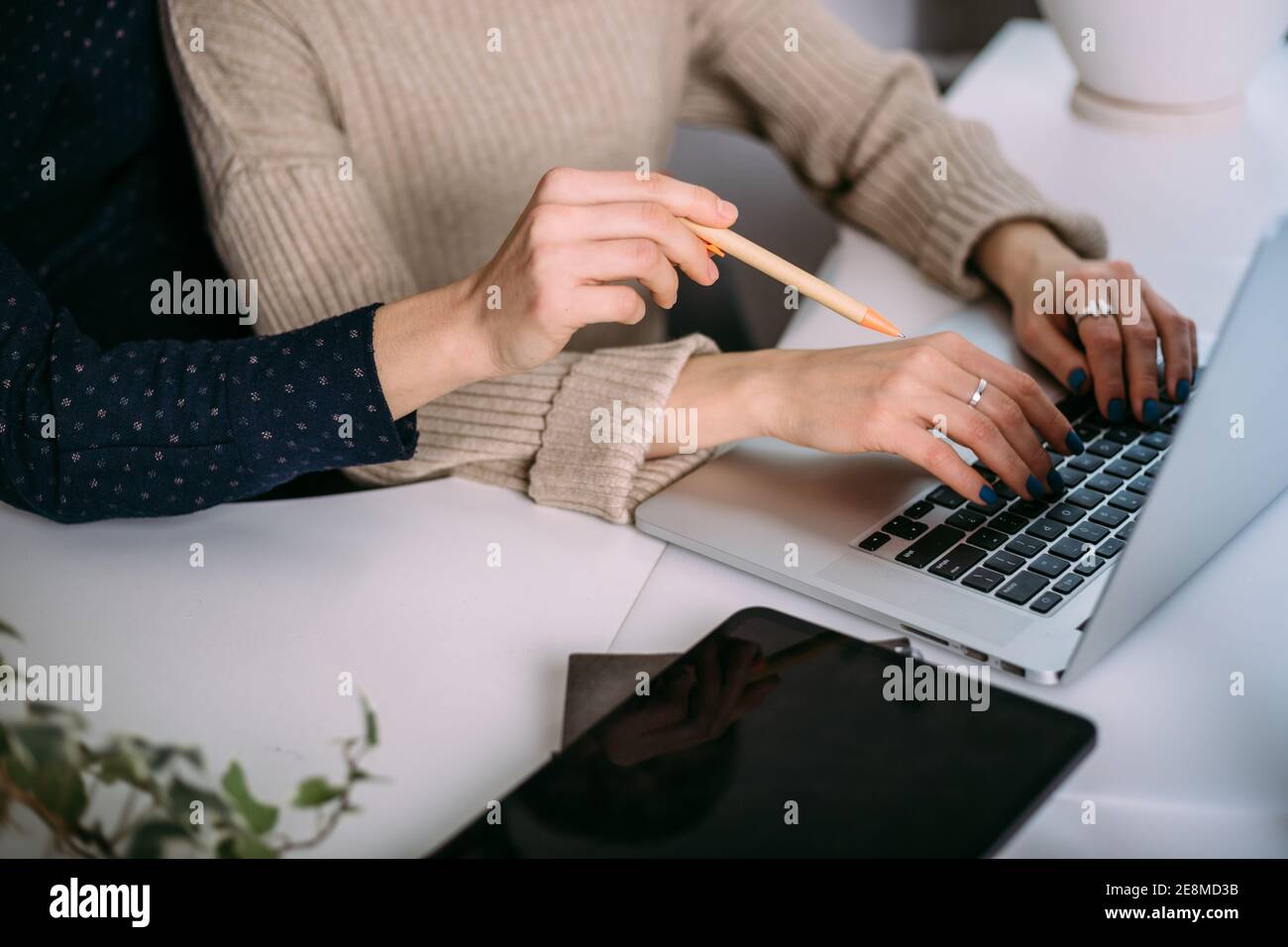 Two girls work side by side in the office on a laptop. Interaction of ...