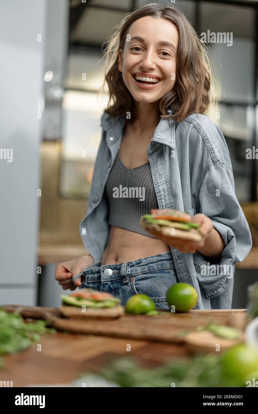 Happy slim woman showing her weight loss Stock Photo - Alamy