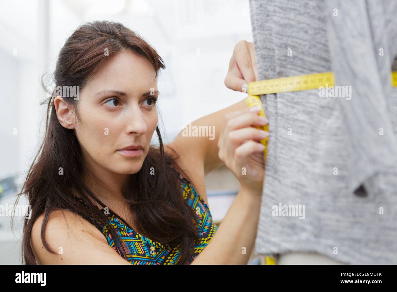 dressmaker using tape around mannequin Stock Photo - Alamy