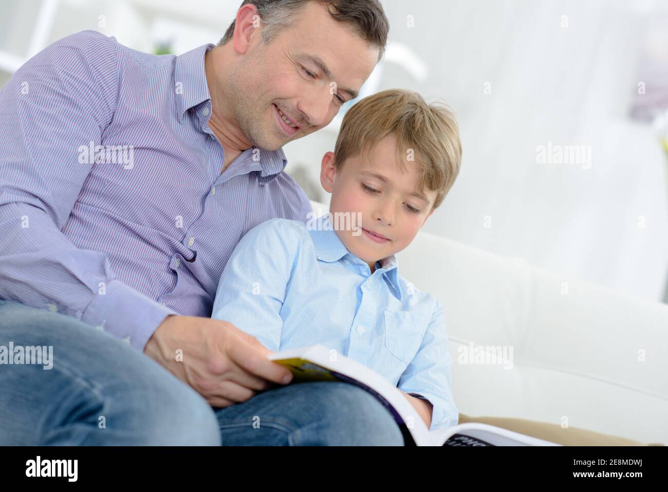 Man reading book with young child Stock Photo - Alamy
