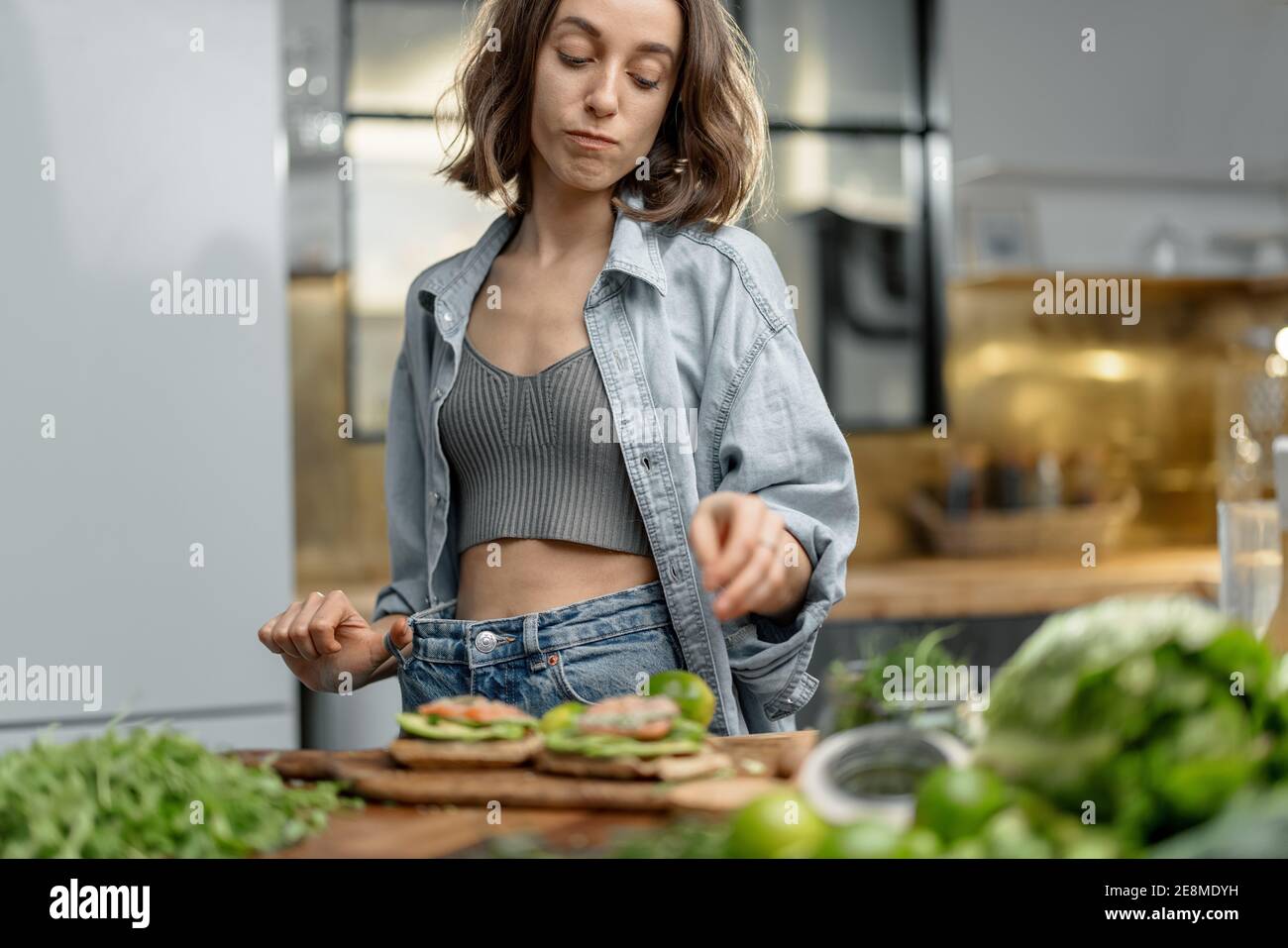 Happy slim woman showing her weight loss Stock Photo - Alamy