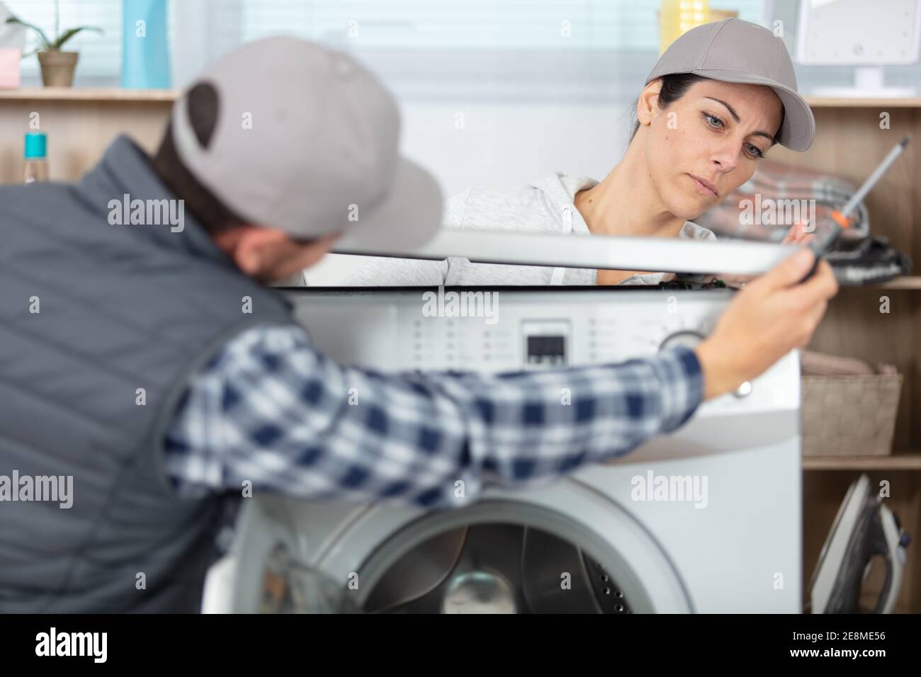 repairman and woman repairing a washing machine Stock Photo - Alamy