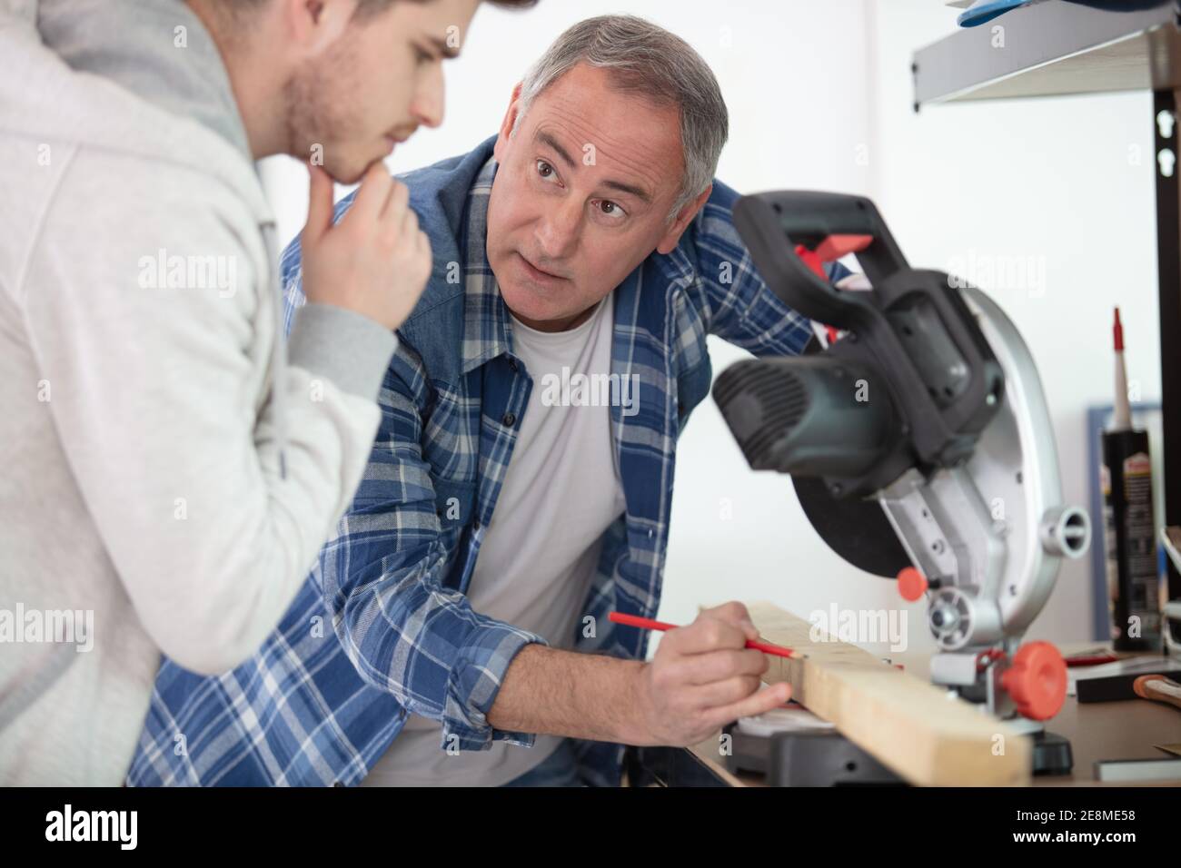 man cutting block of wood to size using circular saw Stock Photo - Alamy