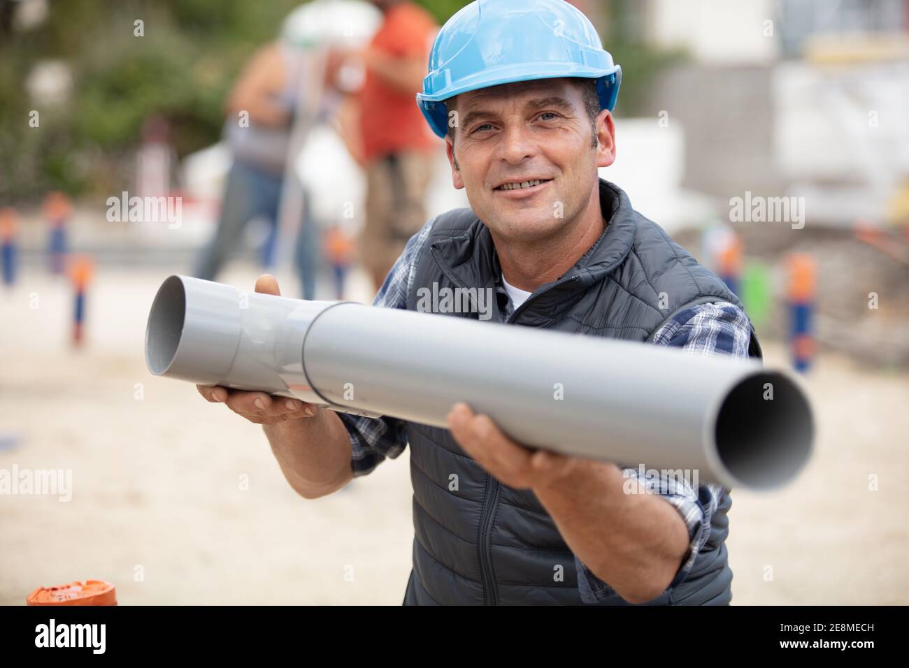 construction worker on site holding pipe Stock Photo - Alamy