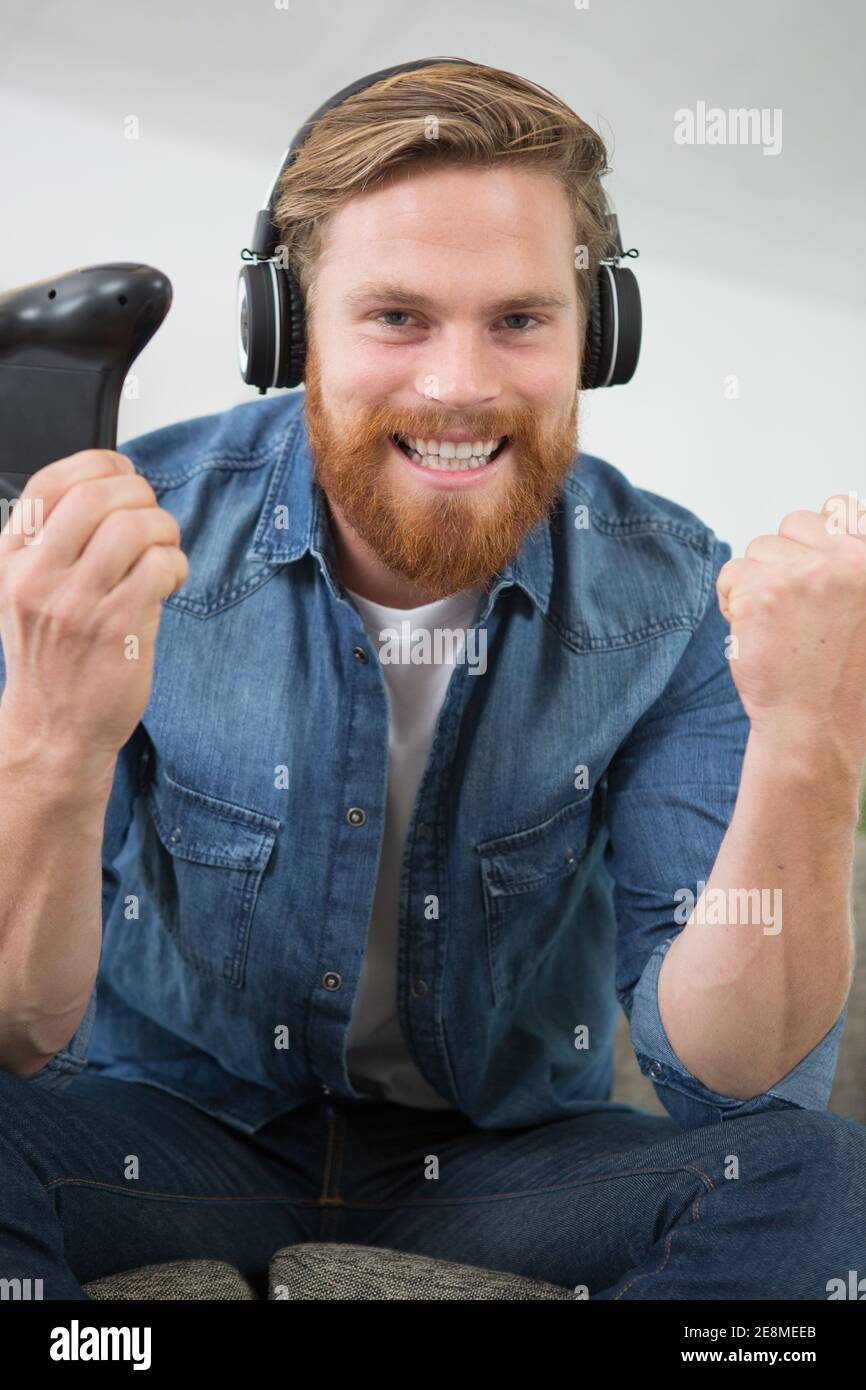 joyful bristled young man holding a video game controller Stock Photo ...