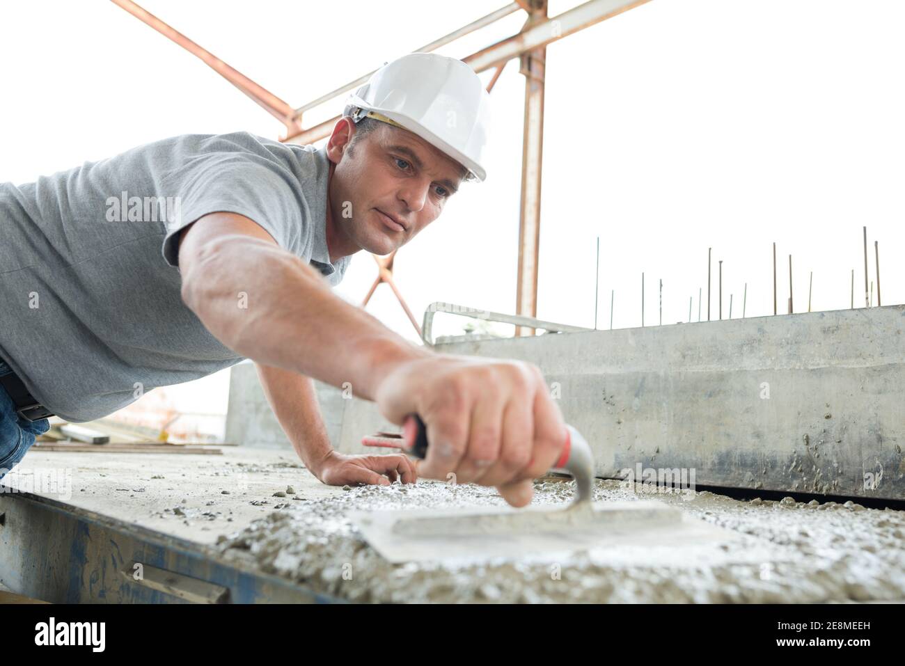 construction worker applying cement in factory floor Stock Photo - Alamy