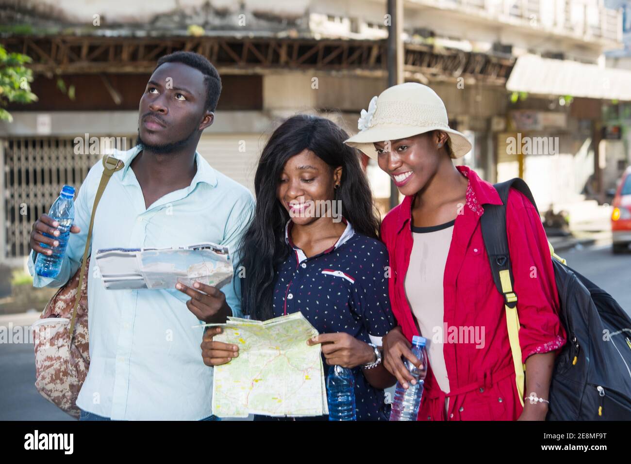 group of young tourists standing staring at map while smiling Stock ...