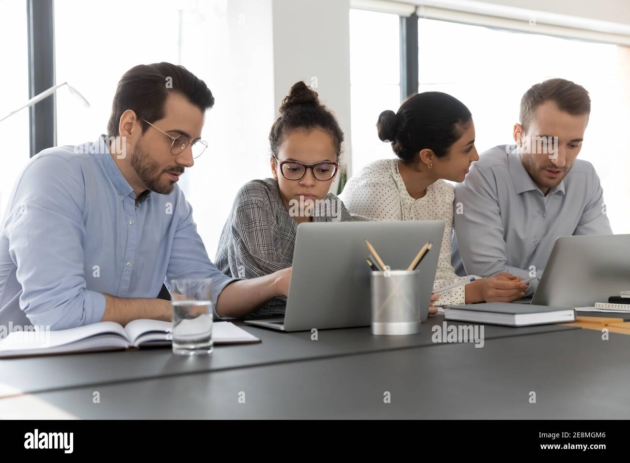 Employees working at computer together, discussing content Stock Photo ...